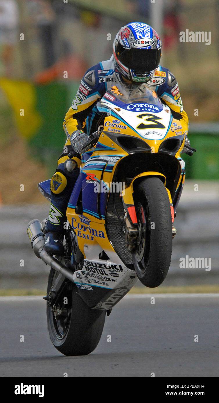 Italy's Max Biaggi performs a 'wheelie' to celebrate his victory in the ...