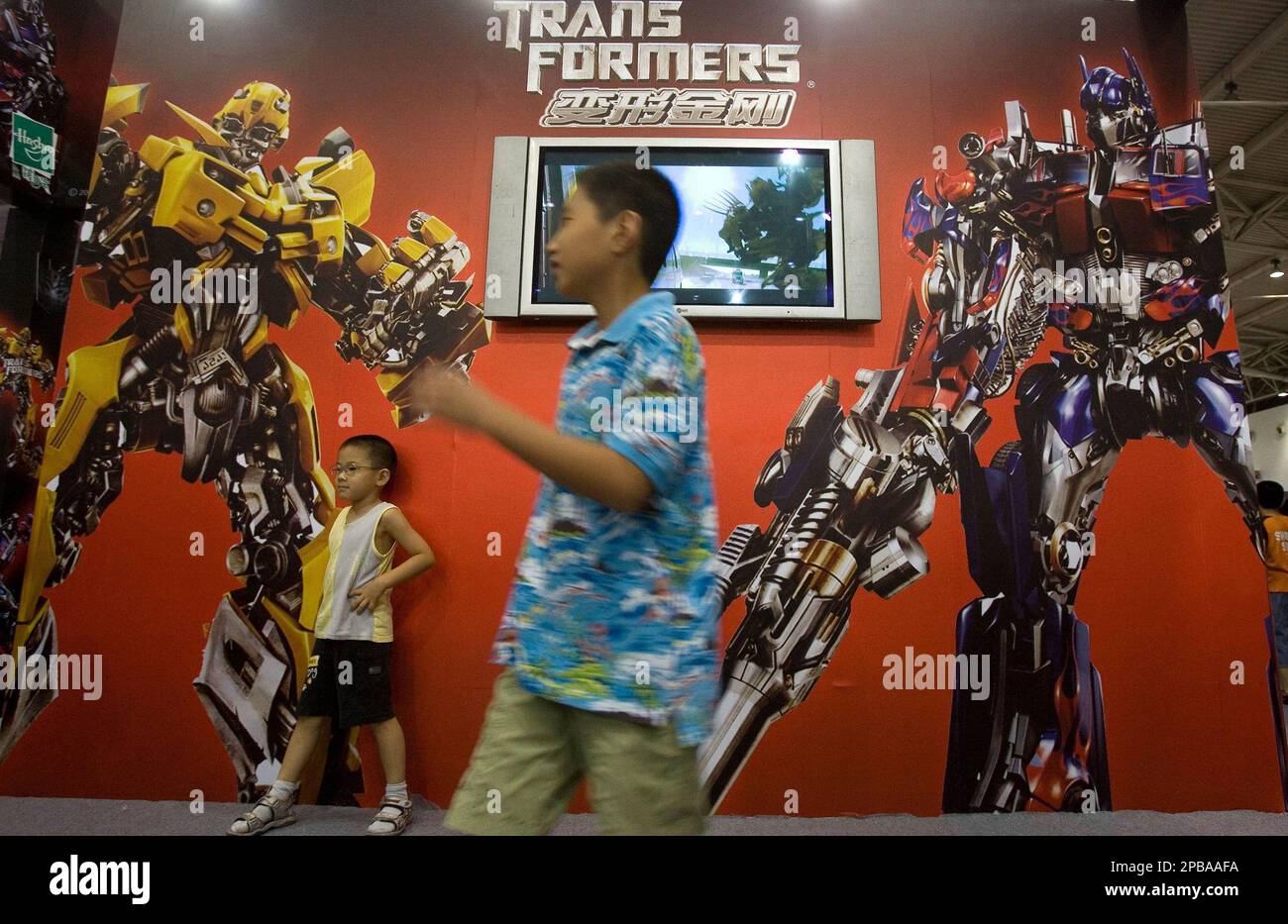 Chinese children pose for photos near an advertisement for the ...