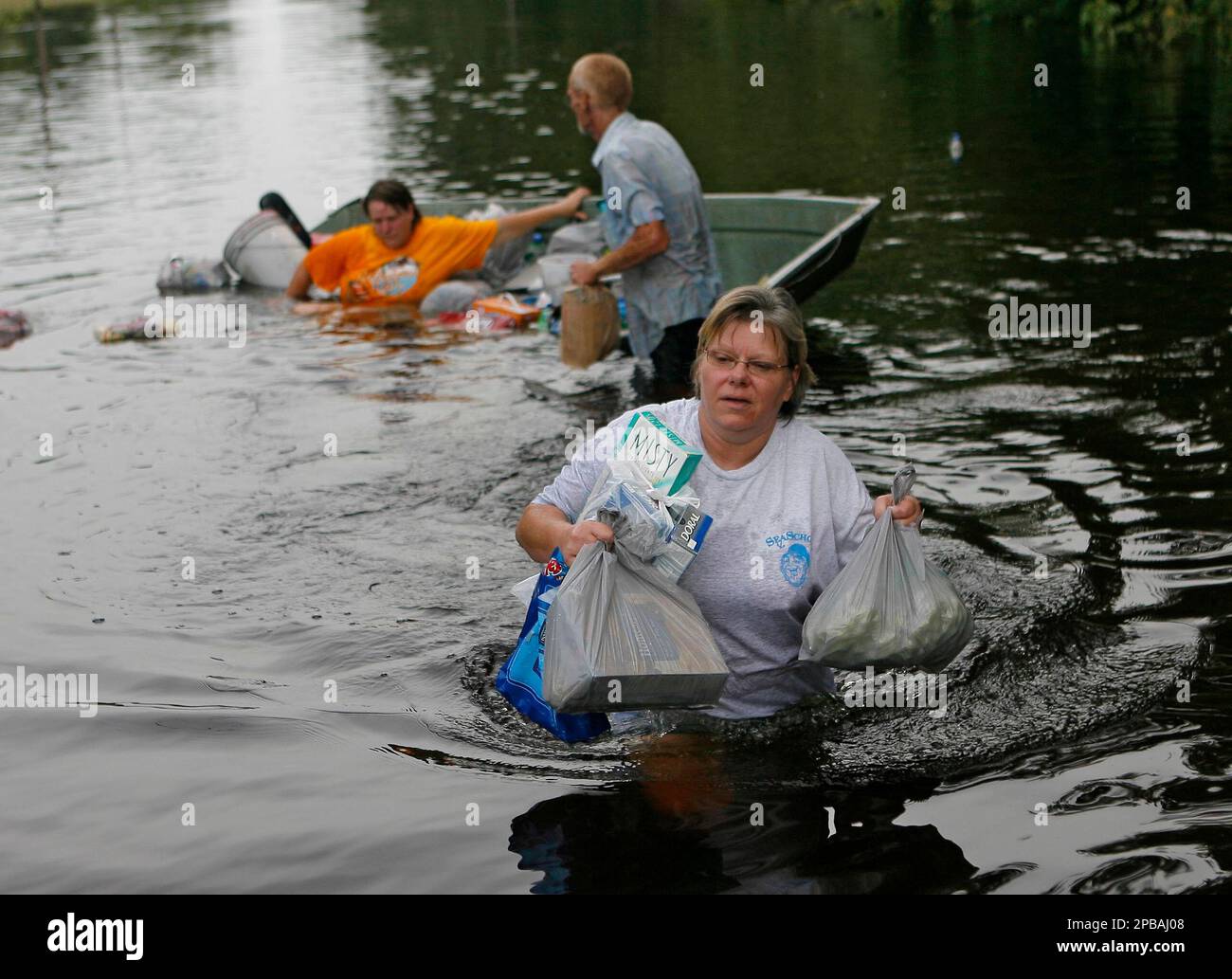 Cindy Pomeroy (foreground) carries supplies to her boat after the boat ...