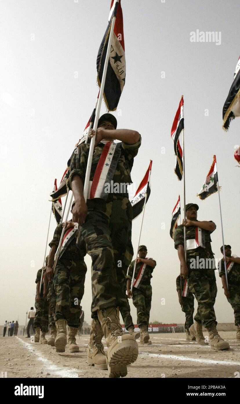 Iraqi police academy graduates carry the Iraqi flag as they march in ...