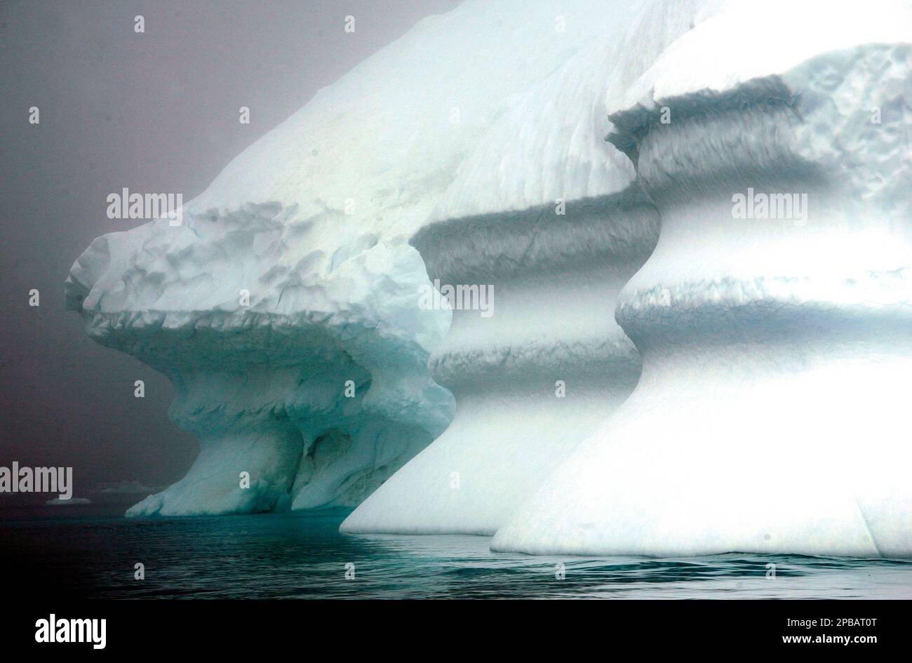 An iceberg melts in circular patterns in Kulusuk Bay, eastern Greenland ...
