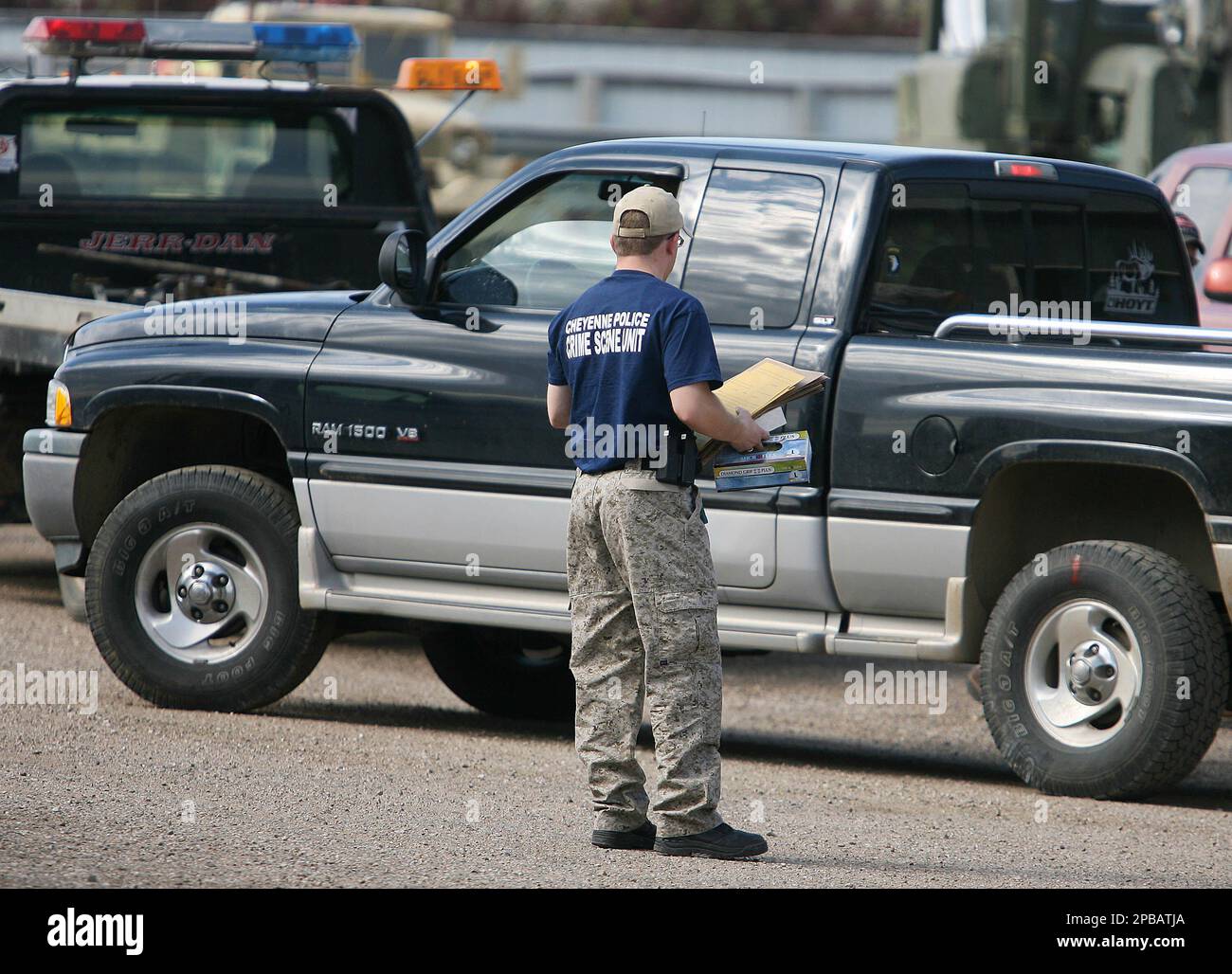 A Cheyenne Police crime scene unit investigator watches as a pickup ...
