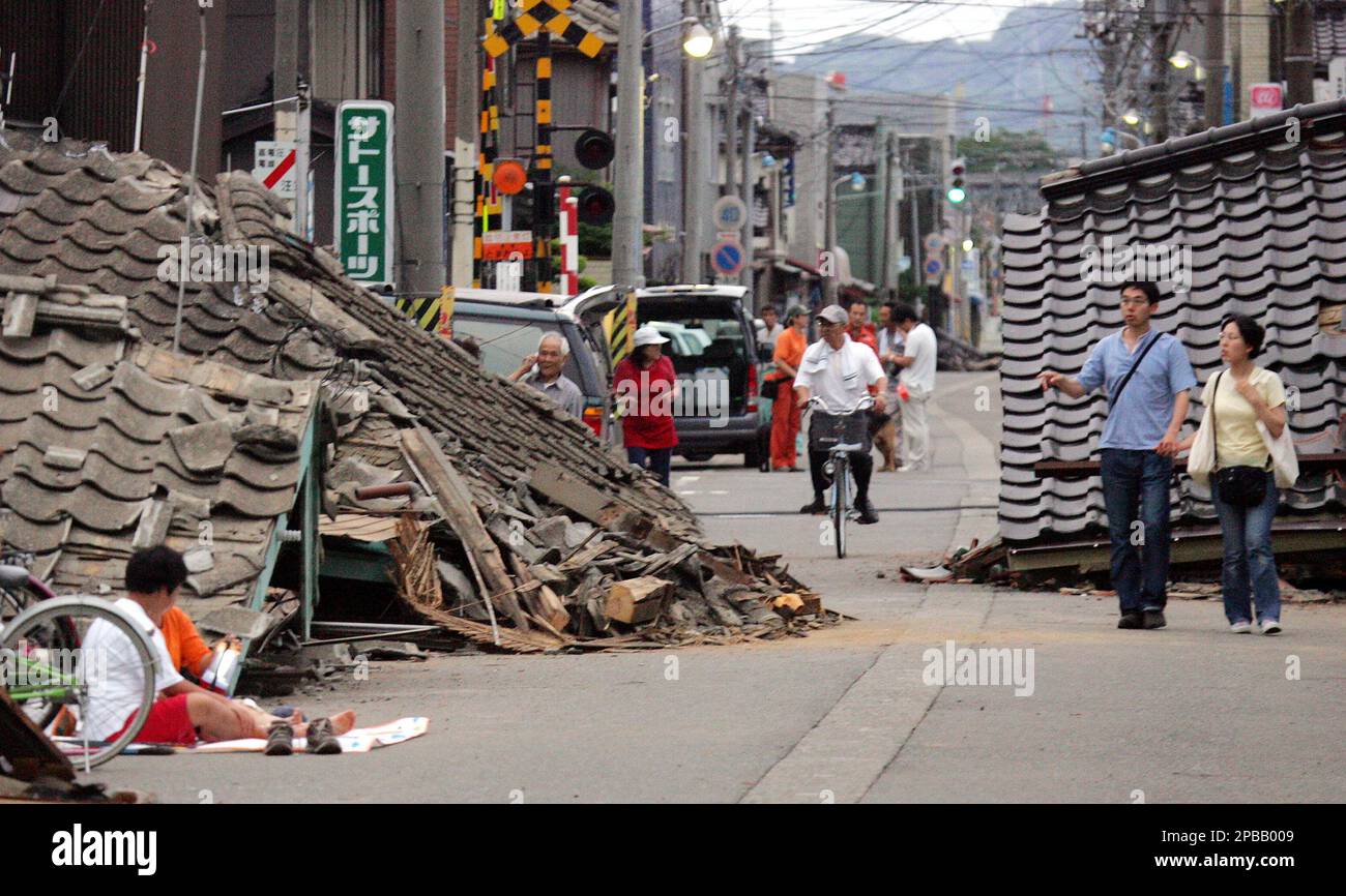 People hang out around destroyed house in Kashiwazaki city, Niigata ...