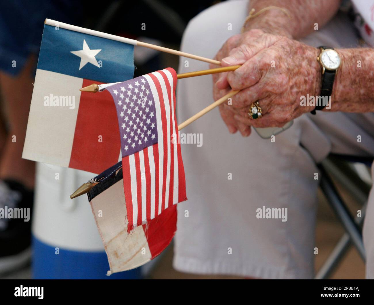 A woman holds a Texas and U.S. flag as she waits for the ceremonial ...