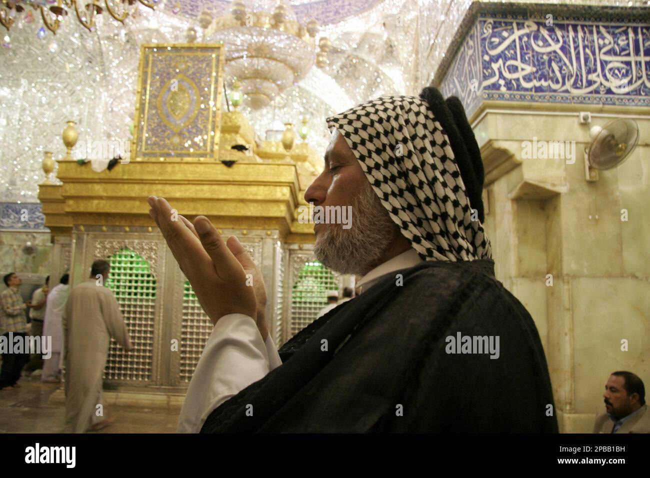 An Iraqi man prays at the Imam Hussein shrine in the Shiite holy city ...