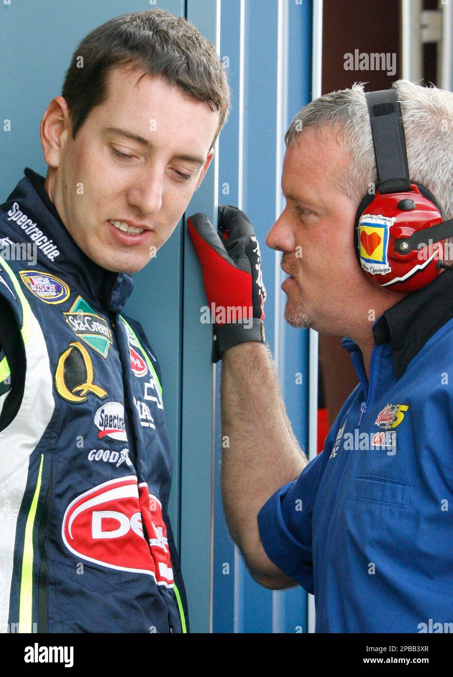 NASCAR driver Kyle Busch, left, talks to a crew member in the garage ...