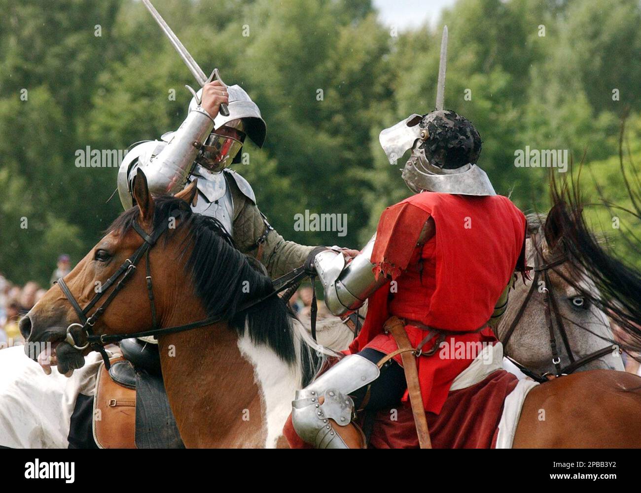 Re-enactors dressed as knights stage a sword fight on horseback during ...