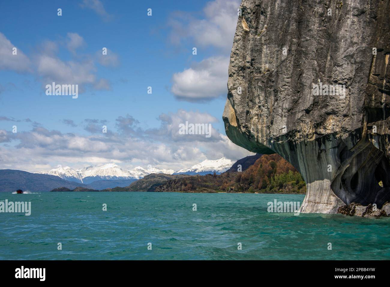 Eroded marble mushroom with distant snow-capped mountains, Marble Caves ...