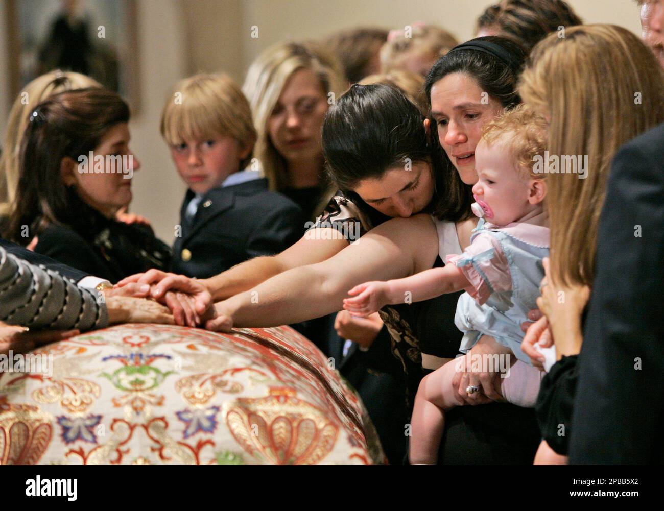 Jennifer Robb, left, places her head on the shoulder of Lucinda Robb as she holds her daughter ...
