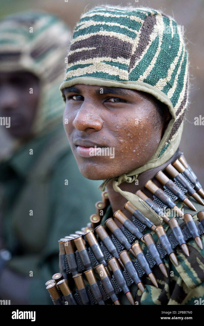 A Tamil Tiger fighter with machine gun bullets around his neck gets ...
