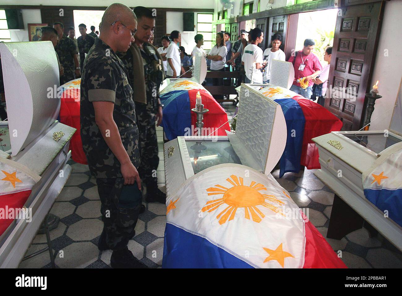 Filipino marines look at the flag-draped coffins of their slain ...