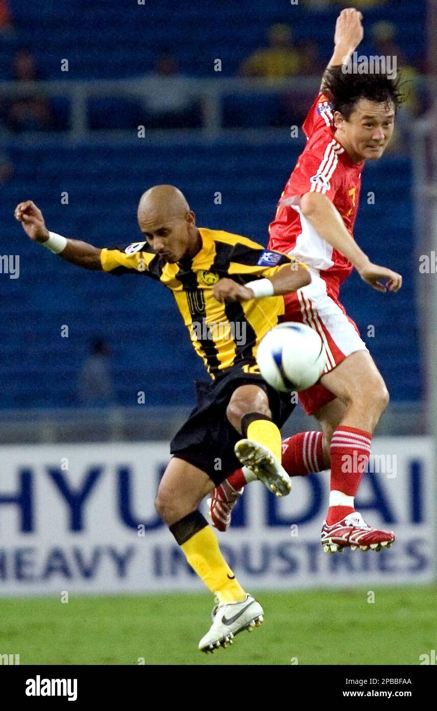 China's Sun Jihai, right, challenges the ball by Malaysia's Mohamad ...