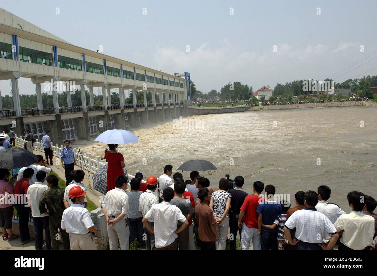 Residents watch flood water rush out from the Wangjiaba dam as it opens ...