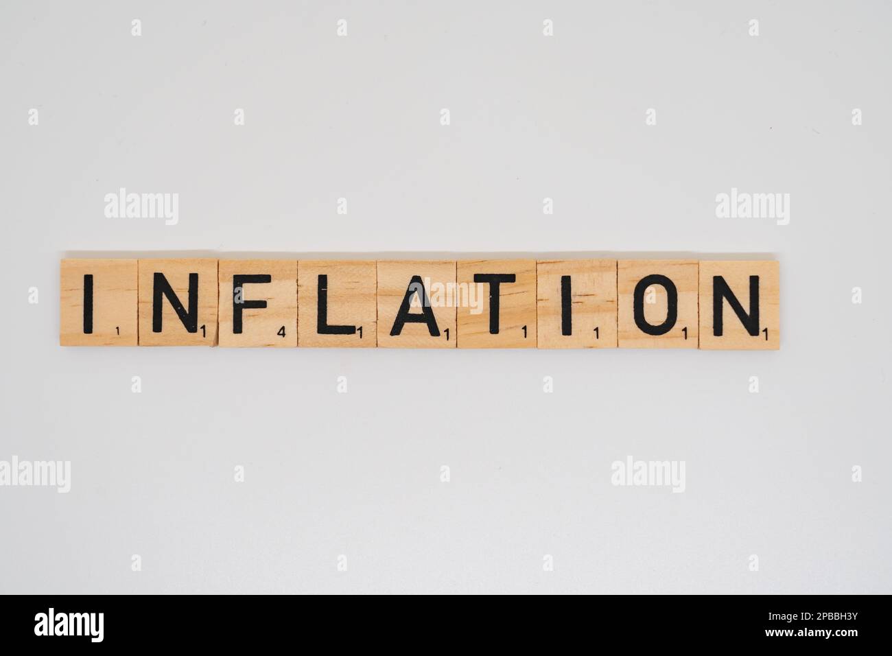 Wooden title spelling the word inflation isolated on a white background ...