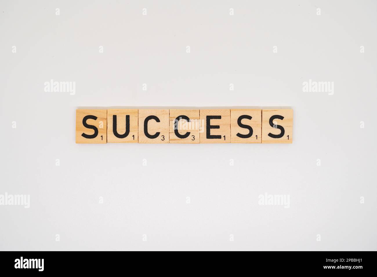 Wooden title spelling the word success isolated on a white background ...