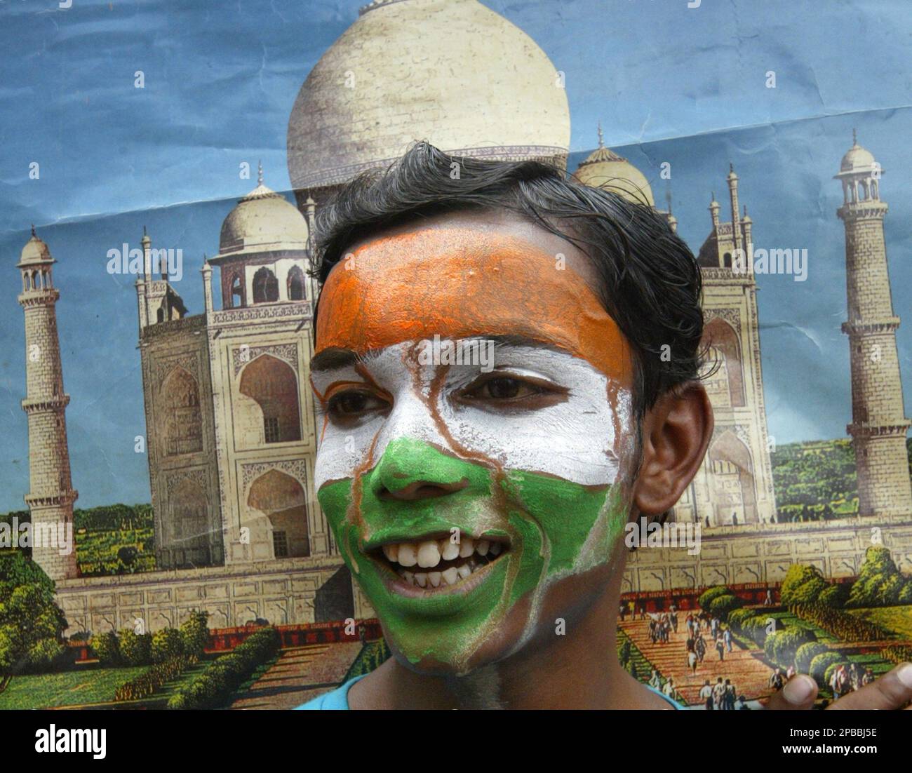 An enthusiast, with his face painted in the colors of the Indian flag ...