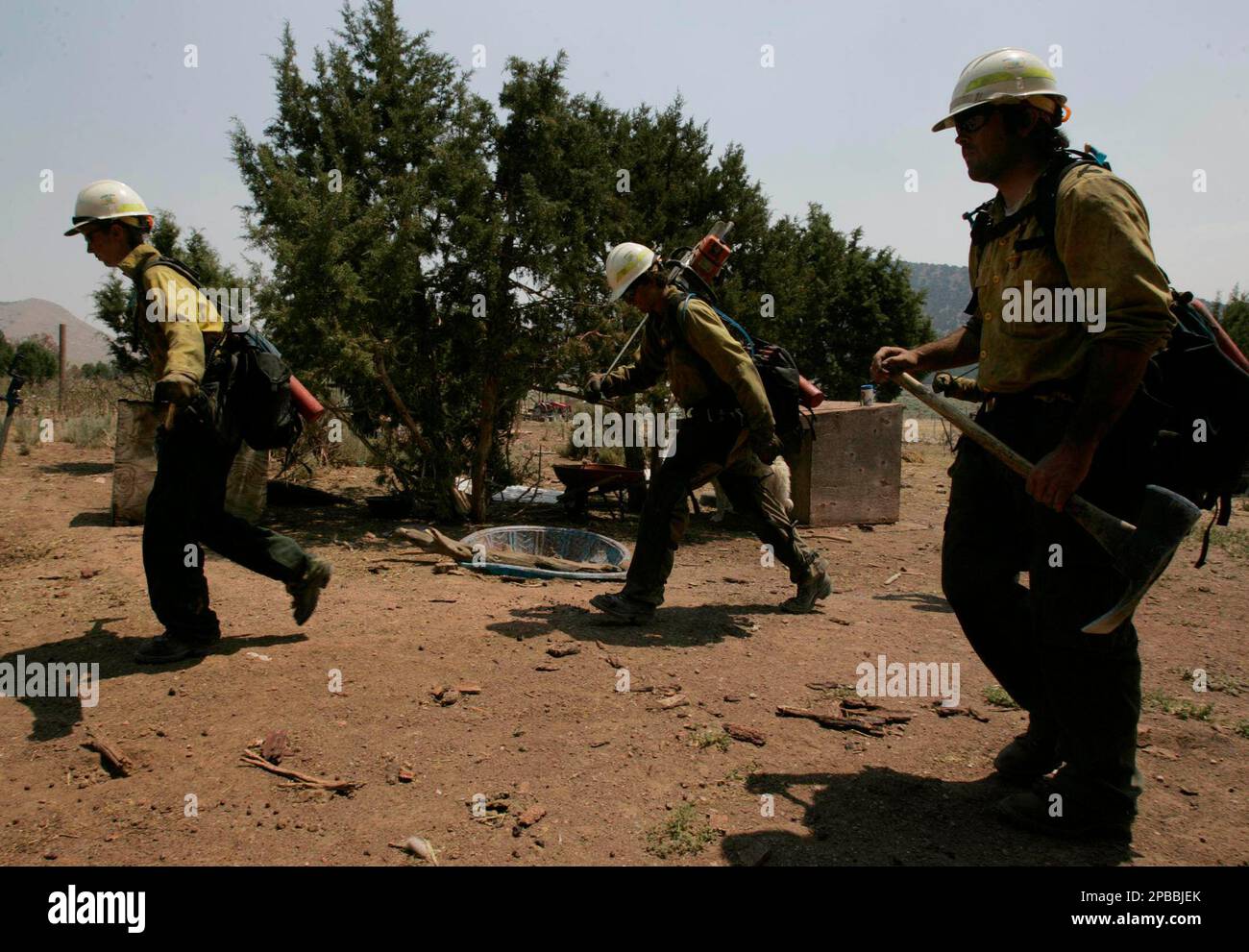 Wildland firefighters head to a ridge above a home during the Milford ...