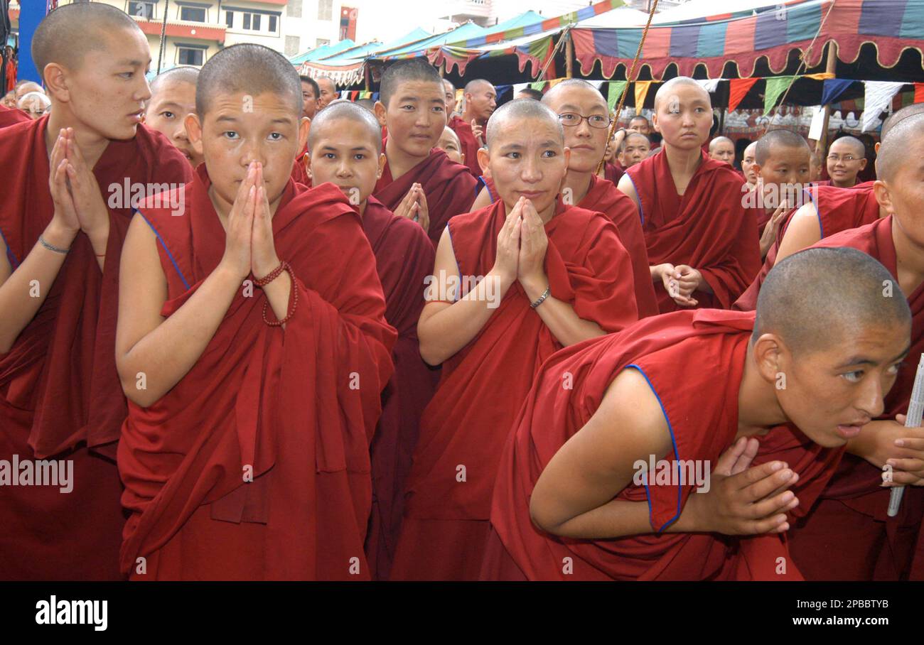 Tibetan monks offer prayers infront of a portrait of their spiritual ...