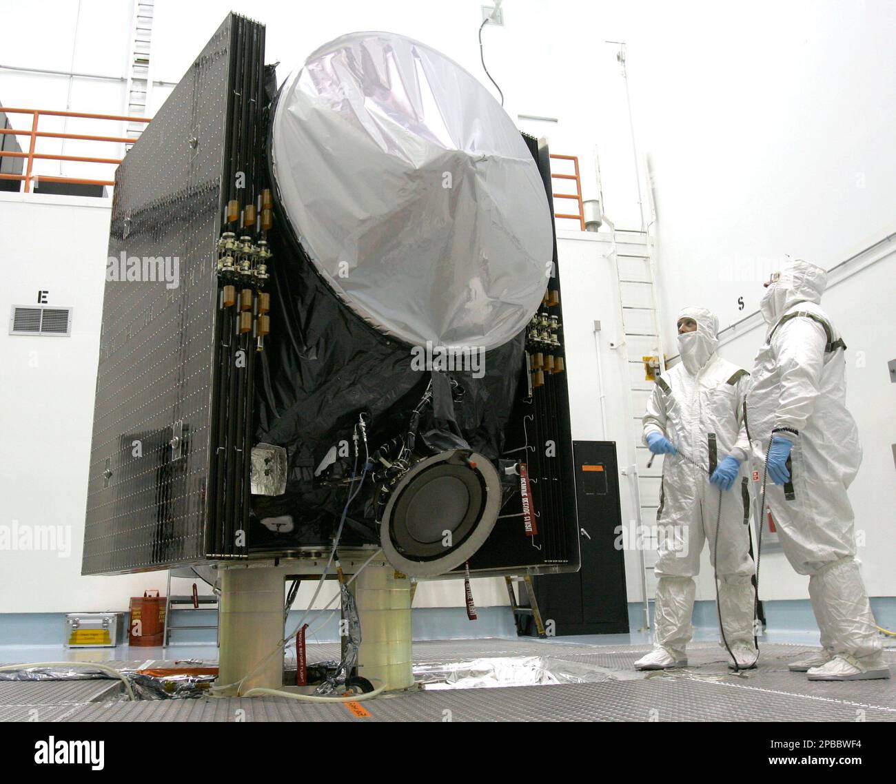 Technicians work on NASA's Dawn spacecraft at the Astrotech processing ...