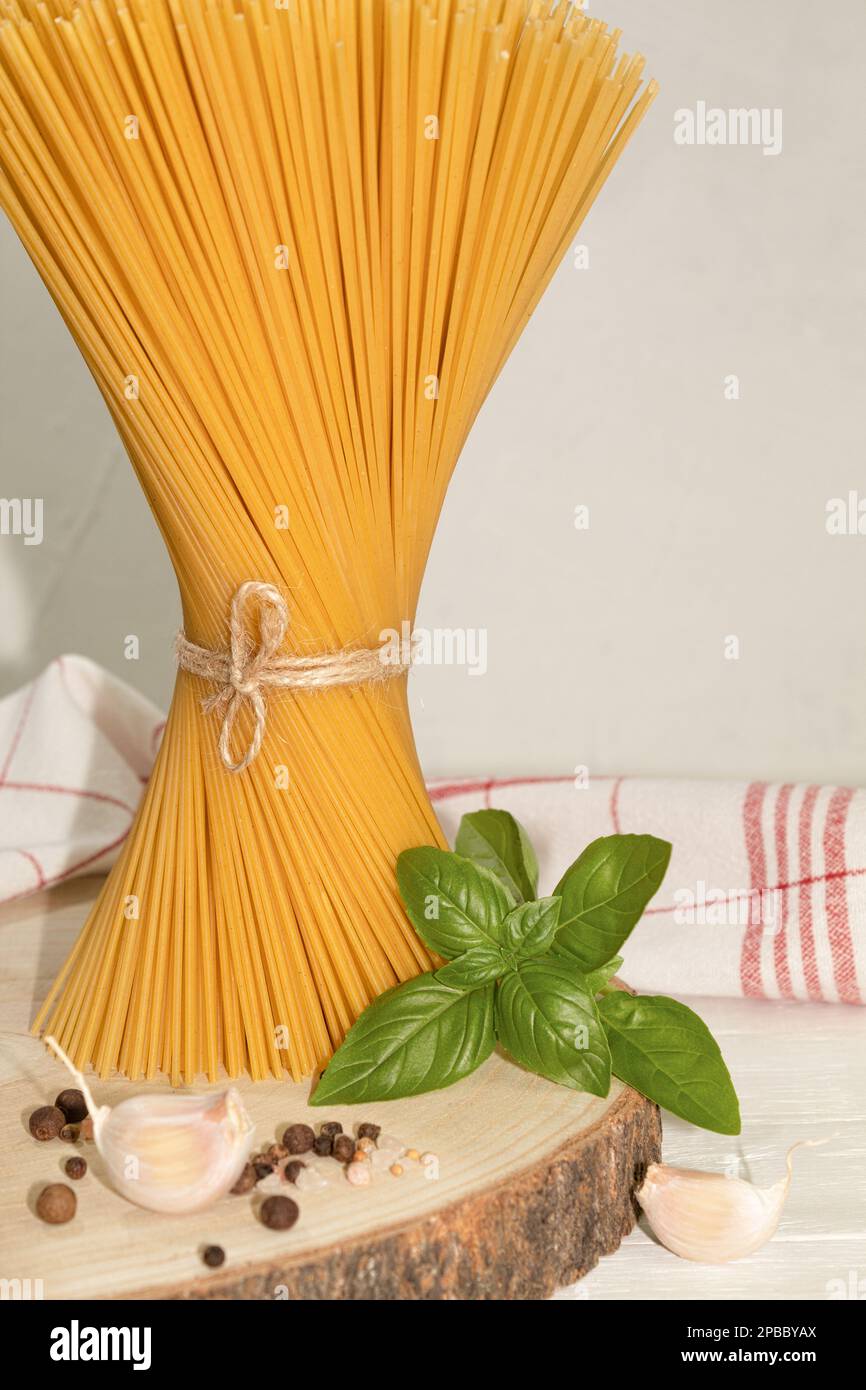 On the table is a pack of spaghetti tied with string. On a light ...