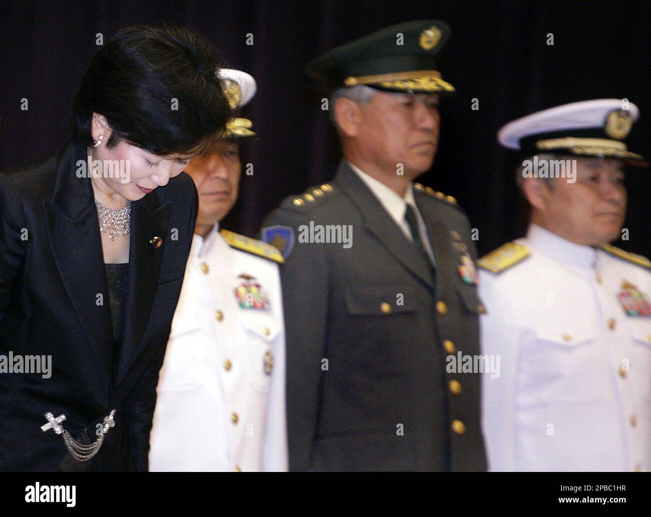 Yuriko Koike, Japan's newly appointed Minister of Defense, bows next to ...