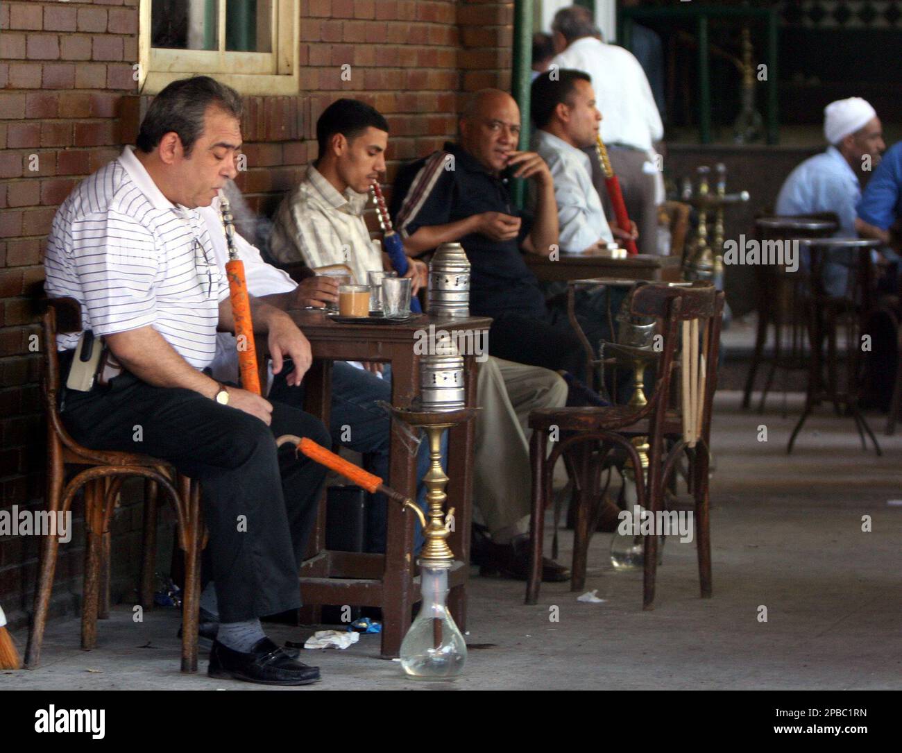 Egyptians smoke traditional water pipes at a coffee shop in Cairo ...