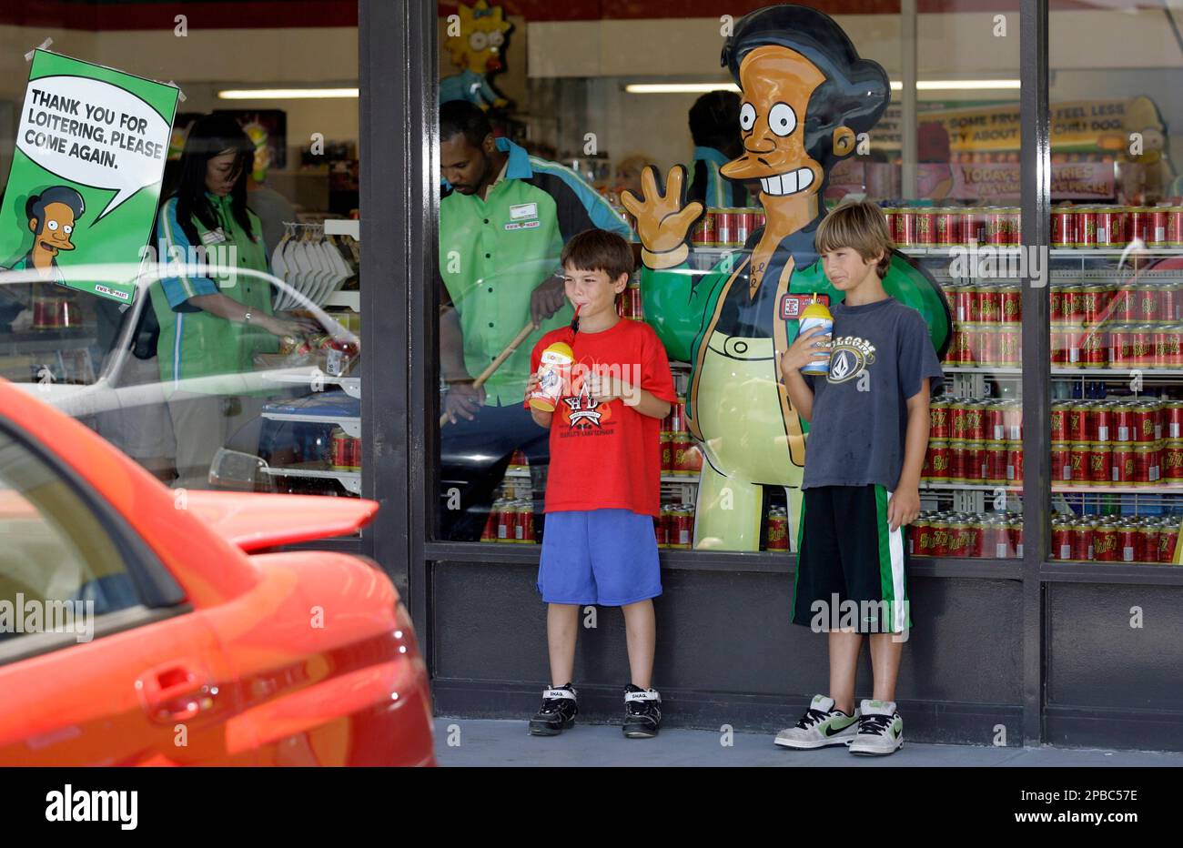 Children pause next top a poster with "The Simpsons" character Apu ...