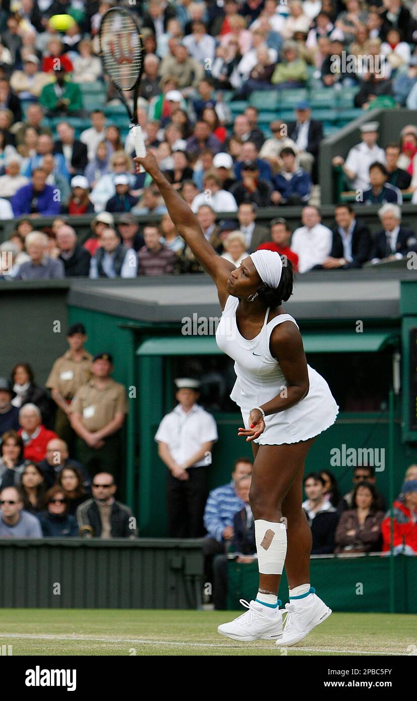 Serena Williams, her calf bandaged following an attack of cramp, serves ...