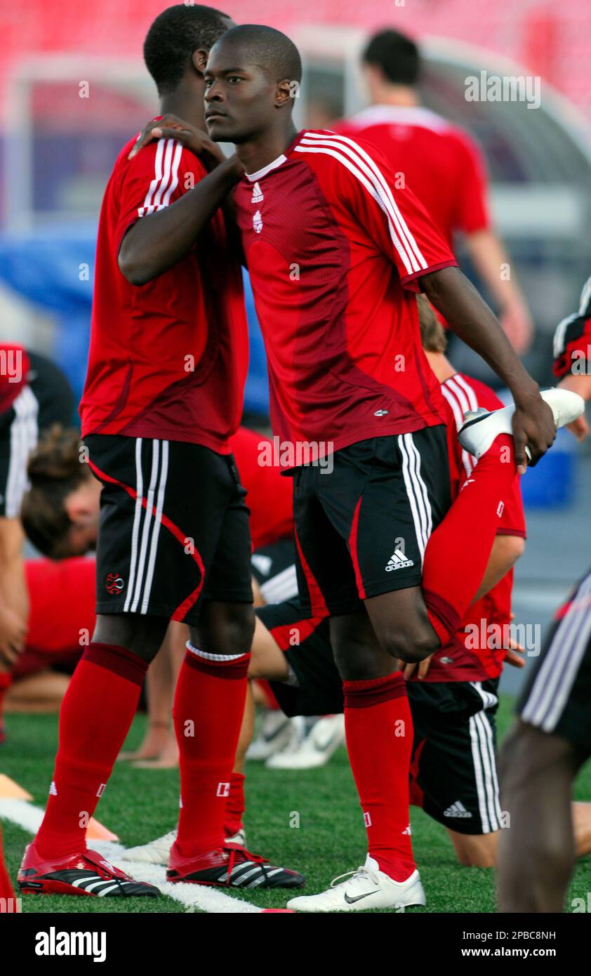 Team Canada's Tosaint Ricketts, right, leans on a teammate to stretch ...