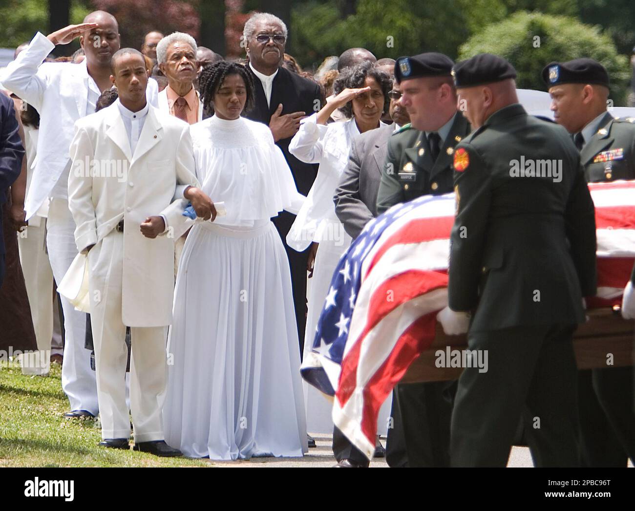 Family members stand together while the body of Sgt. Eric Snell is ...