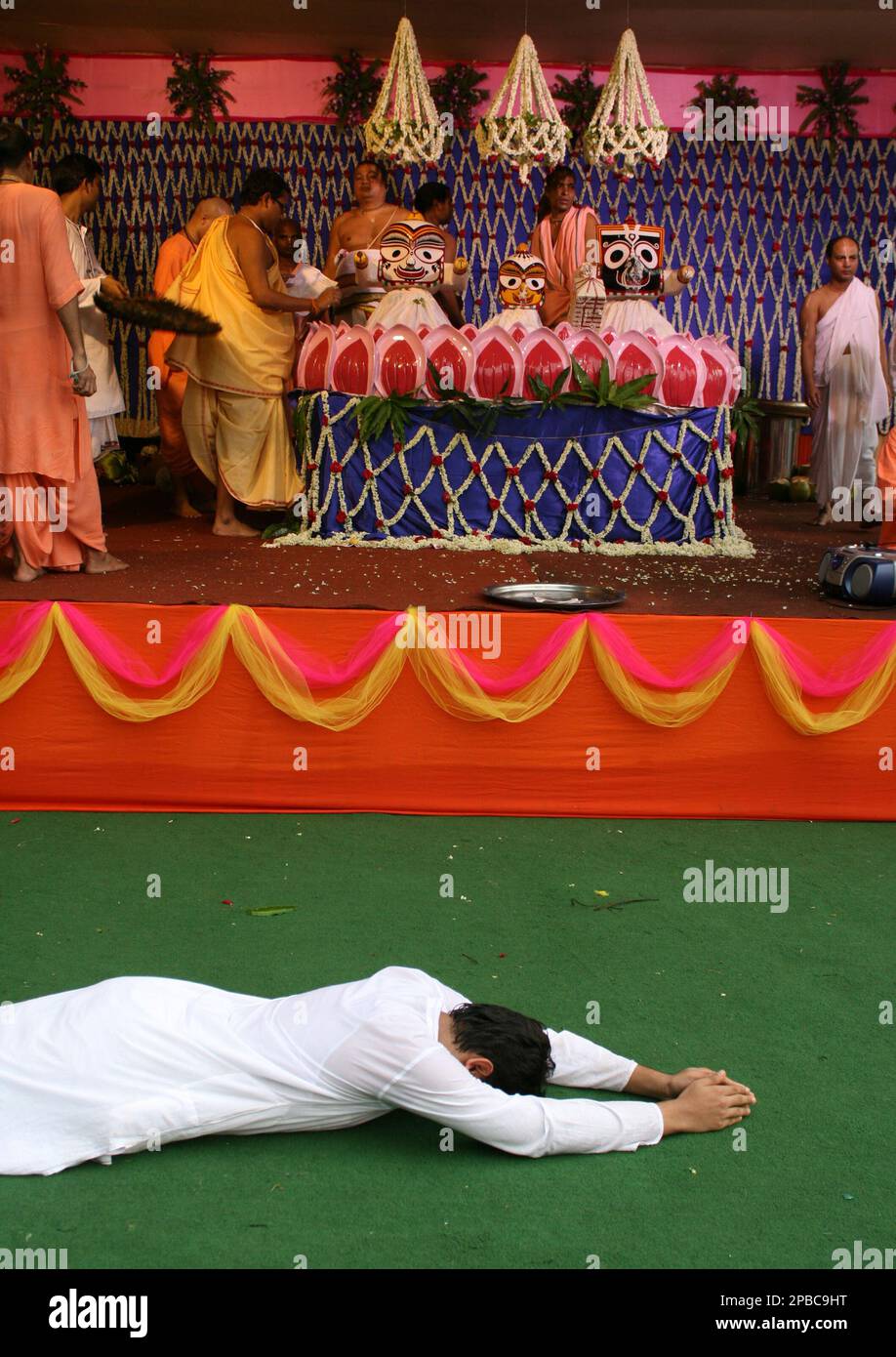 A Hindu devotee prays in front of the images of Lord Jagannath ...