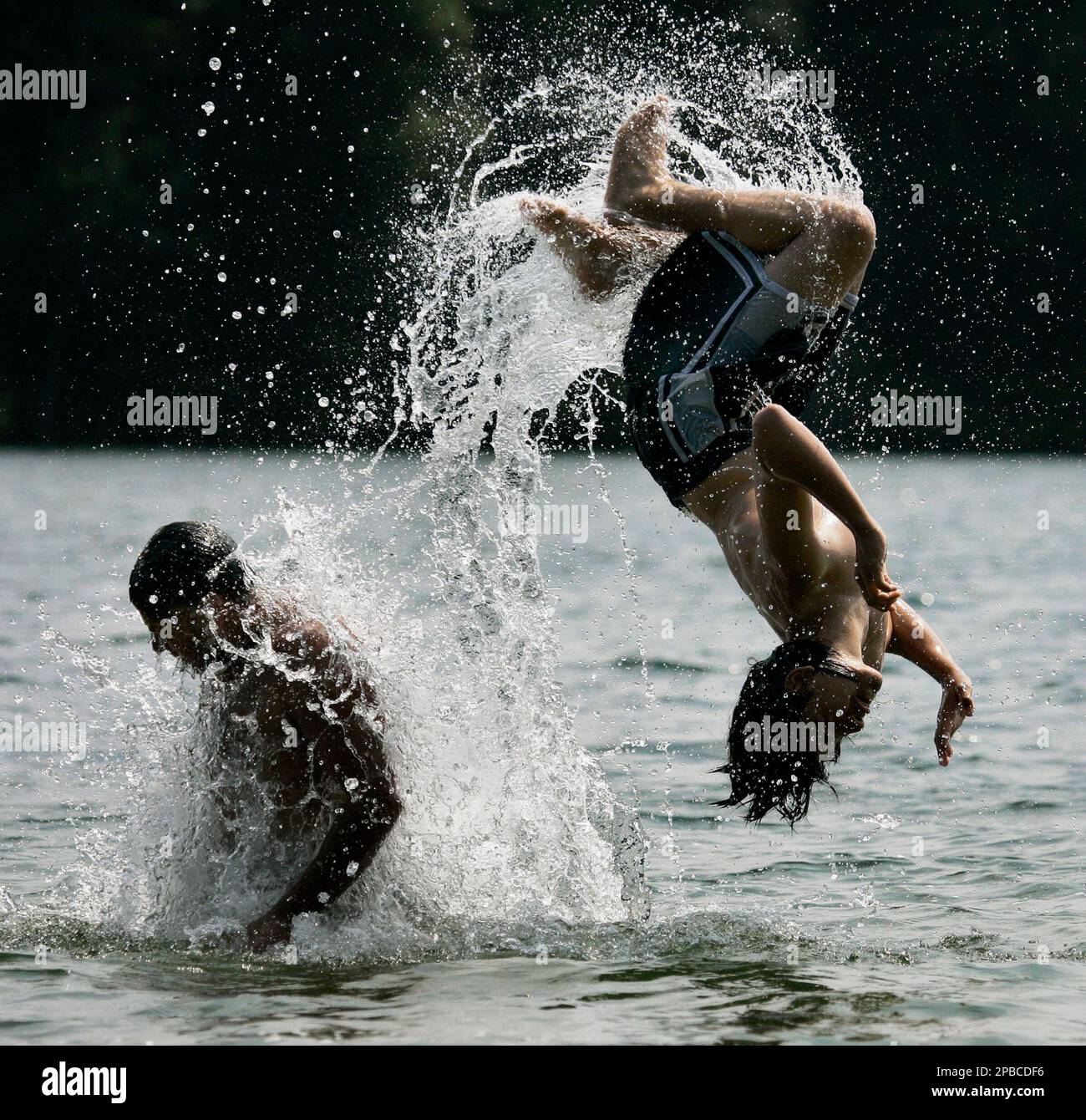 Freddie Roman, 13, right, of Waltham, Mass., is flipped into the water ...