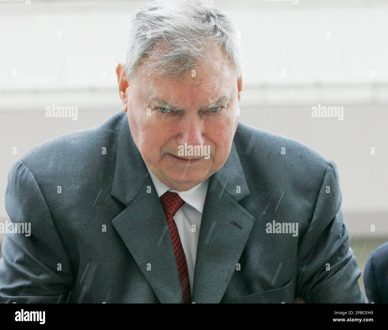 Former state Senator Gene Stipe, is helped across the street in the ...
