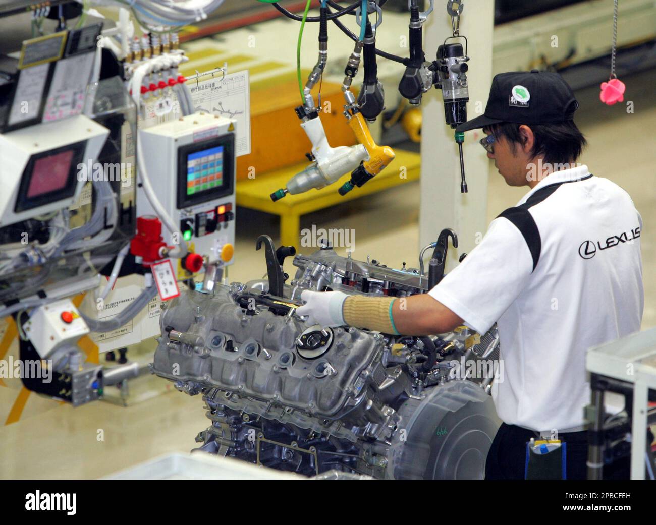 A Toyota Motor Corp. employee works on a lexus engine at the Japanese ...