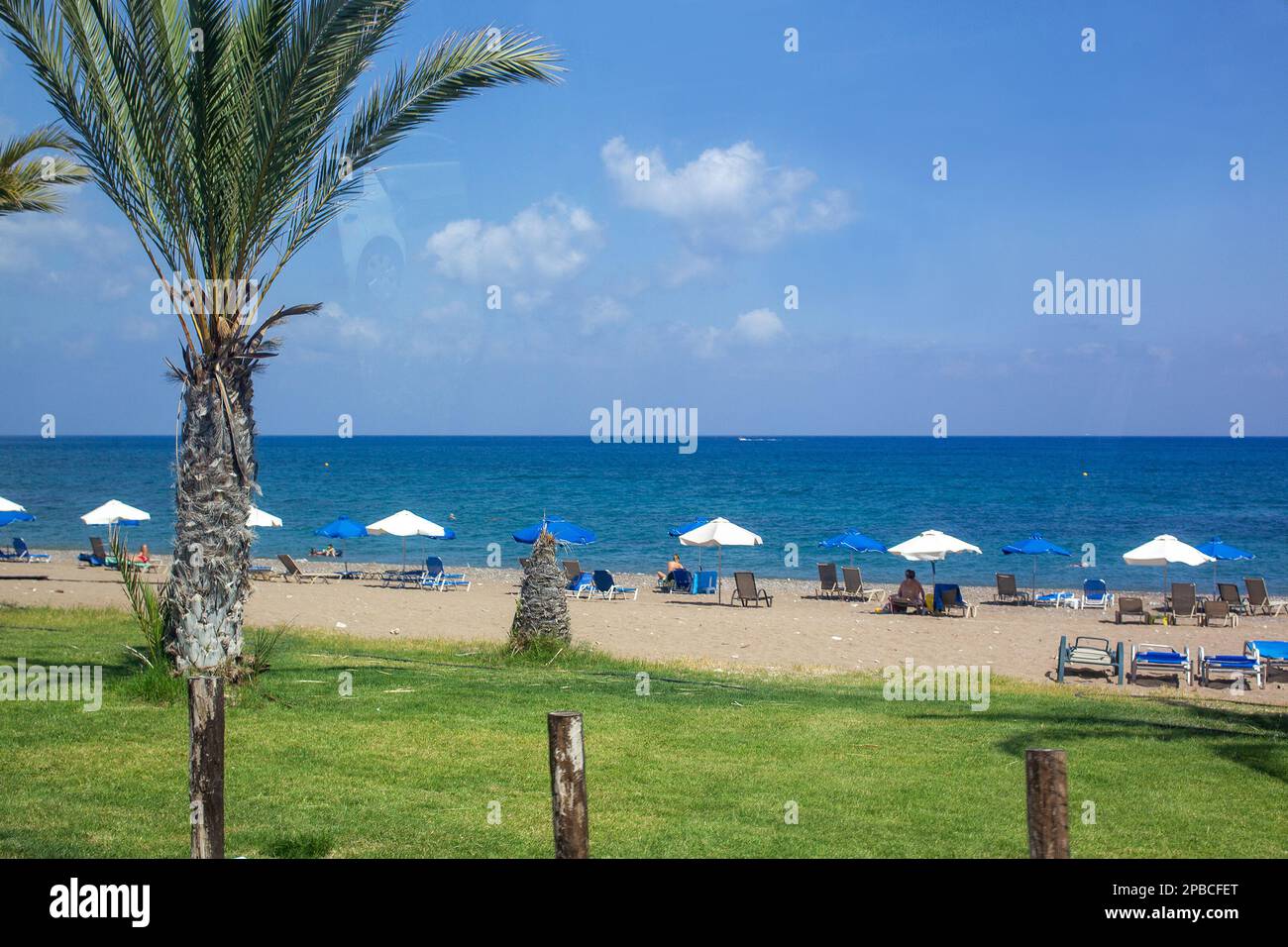 People rest on the beach in Cyprus under tents in August. Speedboat in ...
