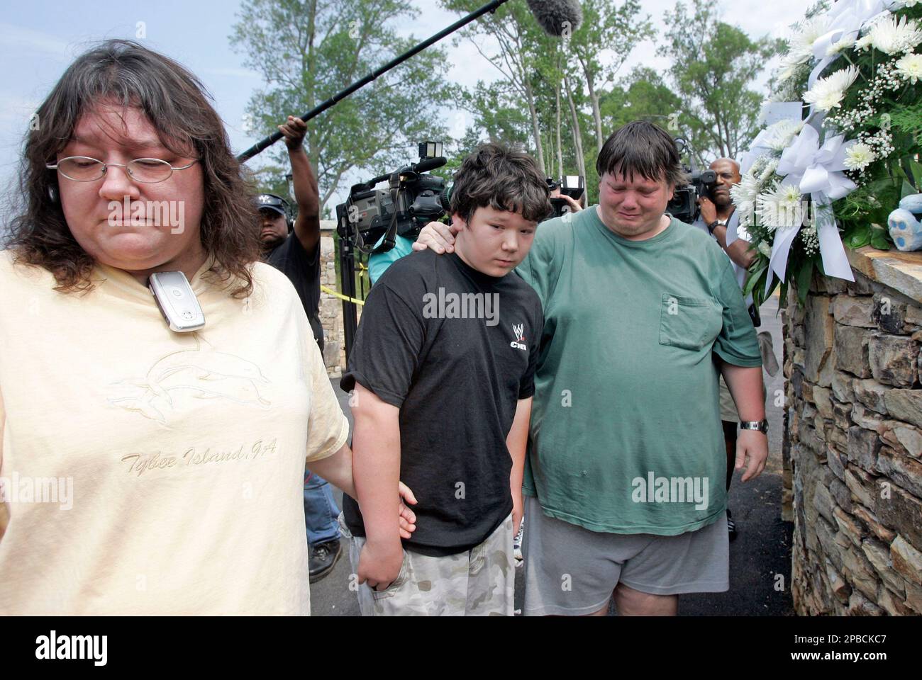 Jimmy Baswell, right, his son Gavin and wife Wanda leave flowers and a ...