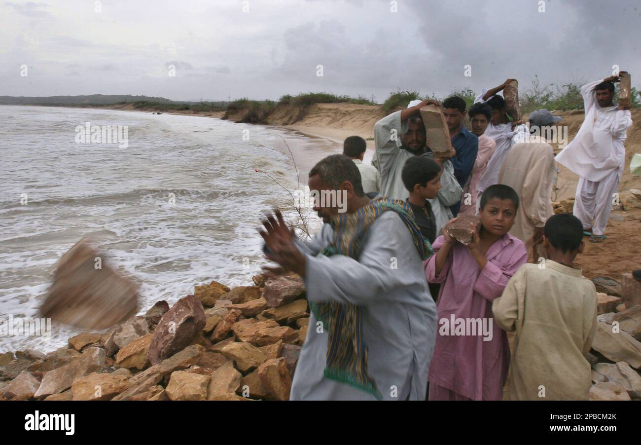 Local residents throw the rocks to repair a weak portion of Ghadani ...