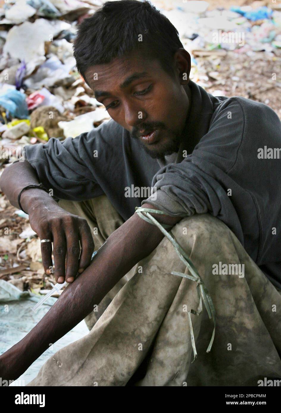 A Pakistani drug addict person injects heroin into himself on the ...
