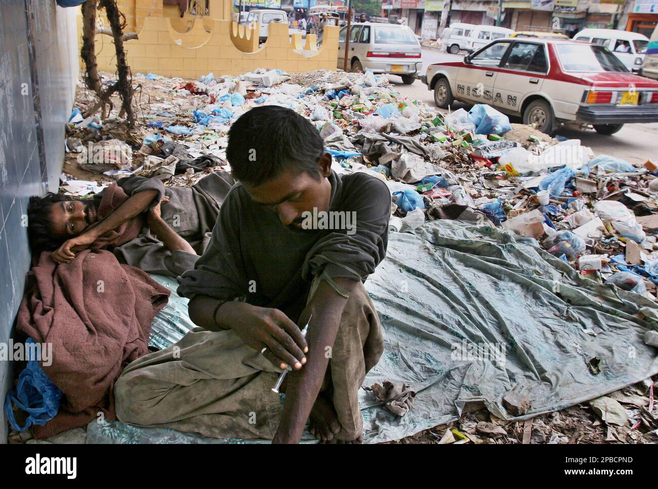 A Pakistani drug addict person injects heroin into himself on the ...