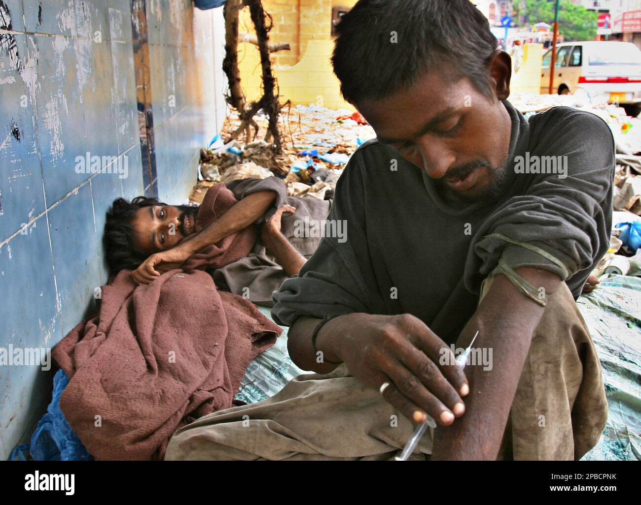 A Pakistani drug addict person injects heroin into himself on the ...