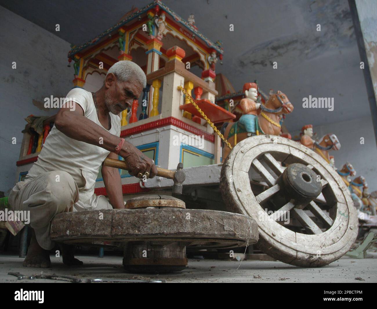 A worker repairs the wheel of a chariot at Lord Jagannath temple ahead ...