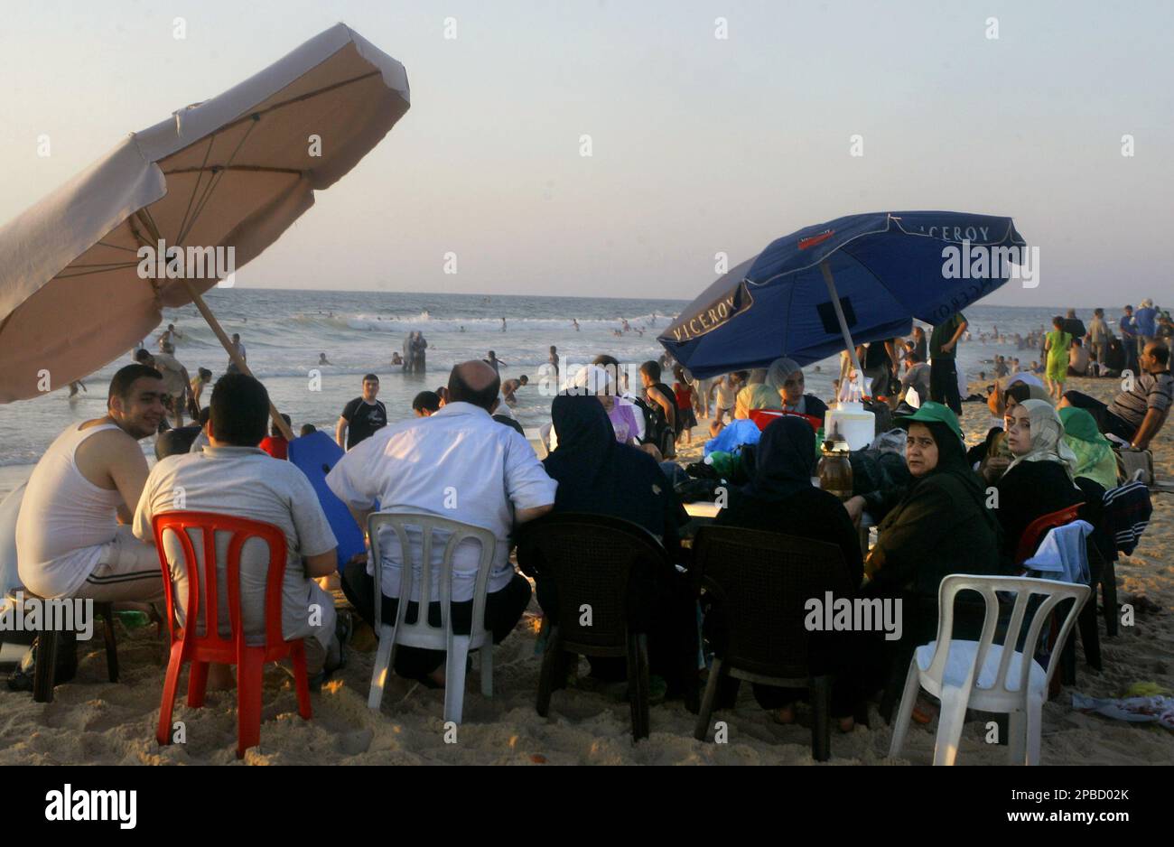 A Palestinian family sit together on the beach in Gaza City, Friday ...