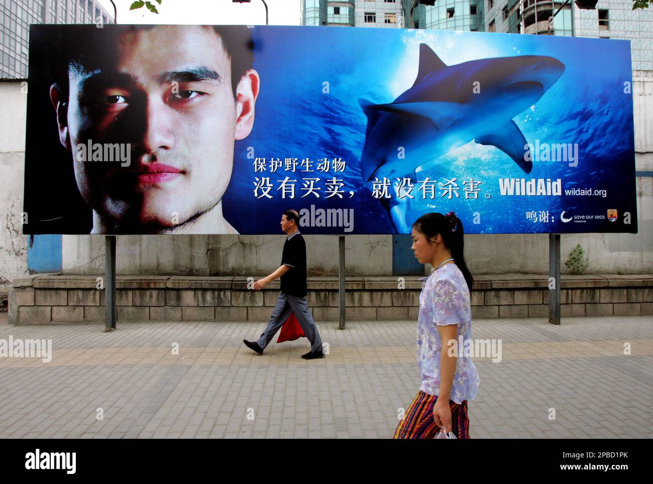 Pedestrians walk past a WildAid billboard featuring Chinese NBA star ...