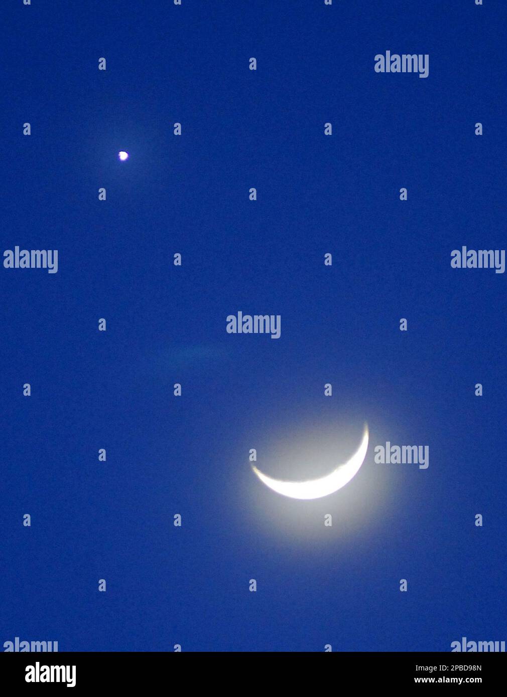 A view of planet Venus eclipsed by a thin crescent moon is seen in ...