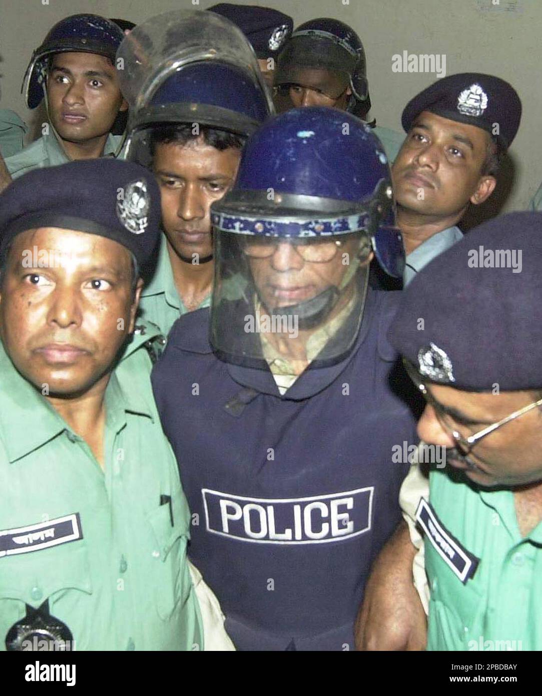 Police officers escort former Bangladeshi military officer A.K.M. Mohiuddin Ahmed, 60, center ...