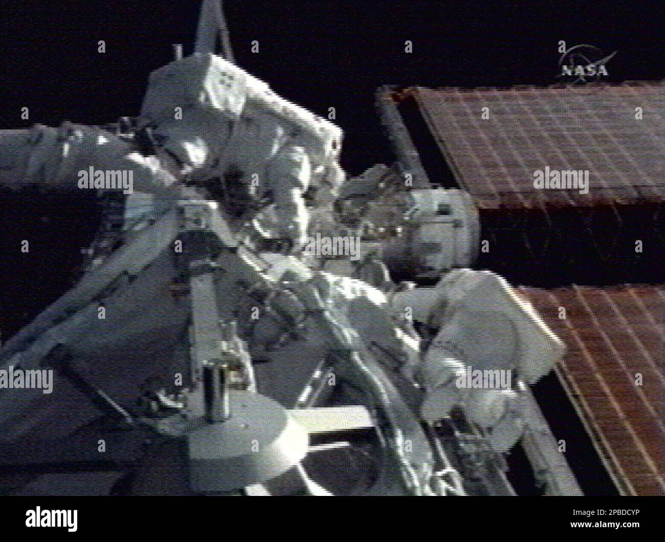 In this image from NASA TV mission specialists Steve Swanson, left, and ...