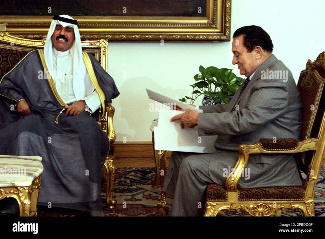 Egyptian President Hosni Mubarak, right, reads a letter from Kuwait's ...