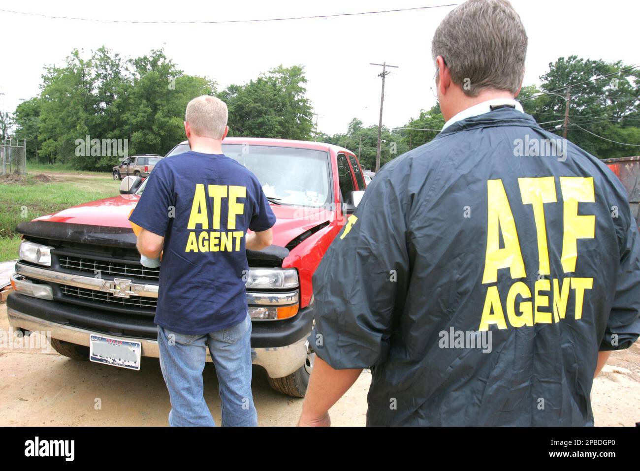 Two ATF agents search fro forensic evidence after a pipe bomb detonated ...