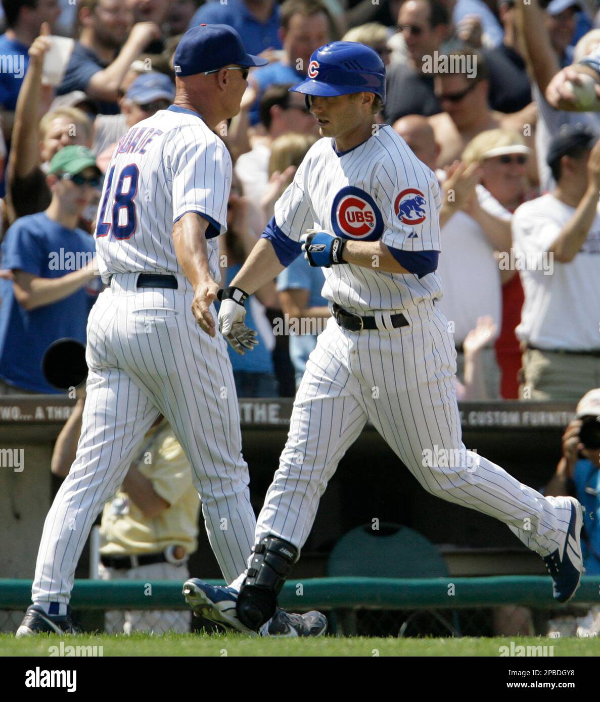Chicago Cubs' Mike Fontenot is congratulated by third base coach Mike ...