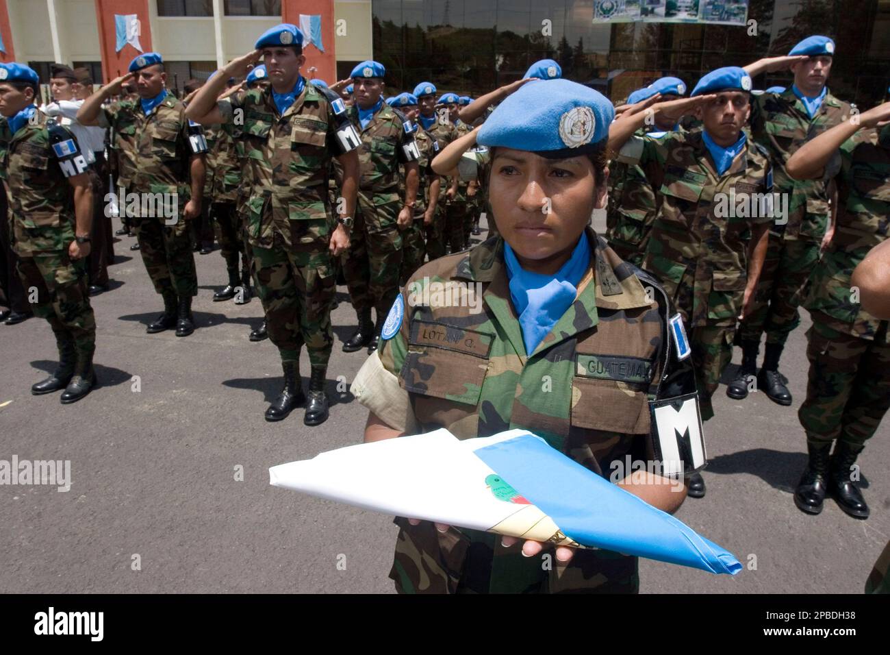 Guatemalan soldier Lucia Lotan holds a her nation's flag at a farewell ...